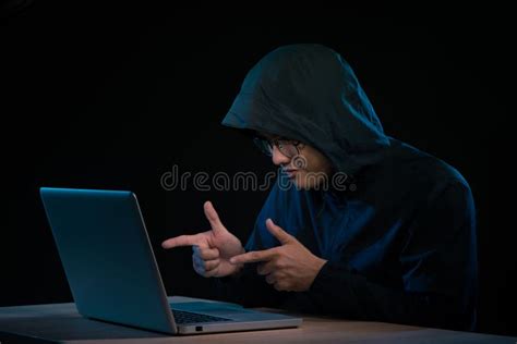 Asian Hacker Hacking Computer Network With Laptop In Dark Cyber