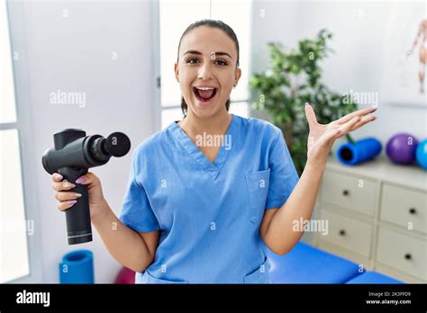 Young Physiotherapist Woman Holding Therapy Massage Gun At Wellness