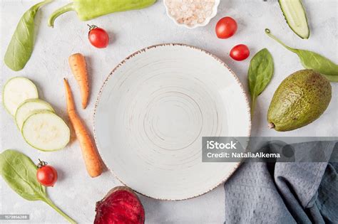 야채와 과일 사이의 중앙에 있는 흰색 접시가 닫힙니다 비건 음식 케토 포드맵 팔레오 저탄수화물 식물성 식단 평면도 복사 공간