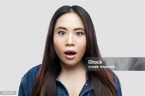 충격 을된 아름 다운 갈색 머리 아시아 젊은 여자의 놀란 얼굴로 카메라를 바라보 고 서 화장과 캐주얼 블루 재킷에 초상화 갈색 머리에 대한 스톡 사진 및 기타 이미지