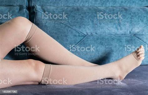 정맥류에 대한 압축 스타킹에있는 소녀의 다리 임신과 정맥류 소파에 집에서 여자의 다리 다리의 통증과 붓기 Phlebitis에