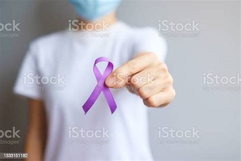 췌장 식도 고환암 세계 알츠하이머 간질 루푸스 사르코이도증 섬유근육통 및 가정 폭력 인식의 달을 위한 보라색 리본을 들고 있는 손 세계 암의 날 개념 10월에 대한 스톡