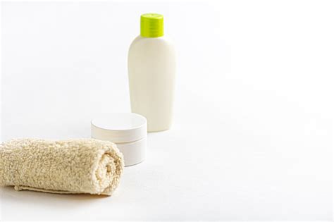 아기 목욕 제품의 모의 샴푸 흰색 배경에 크림에 대한 수건과 항아리에 대한 흰색 병 닫고 텍스트를 위한 공간을 복사합니다 베이비 목욕 액세서리의 개념 0명에 대한 스톡 사진