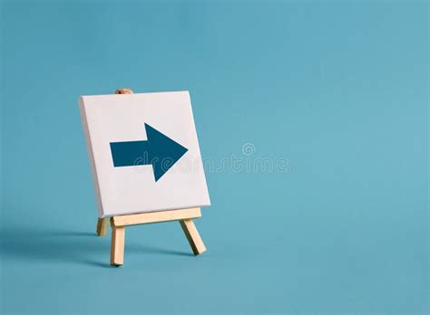 A Canvas With Directional Arrow Sign On An Easel With Blue Background With Copy Space Stock