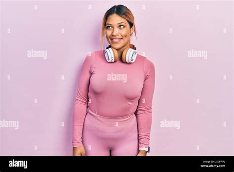 Beautiful Hispanic Woman Wearing Gym Clothes And Using Headphones