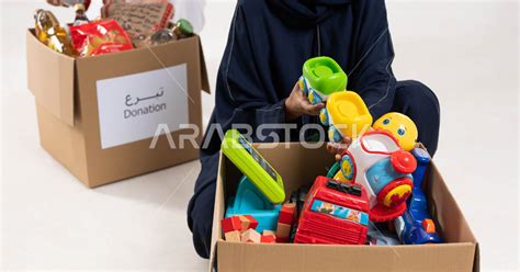 صورة مقربة لامرأة ورجل عربيان خليجيان سعوديان يقومان بتجهيز صناديق