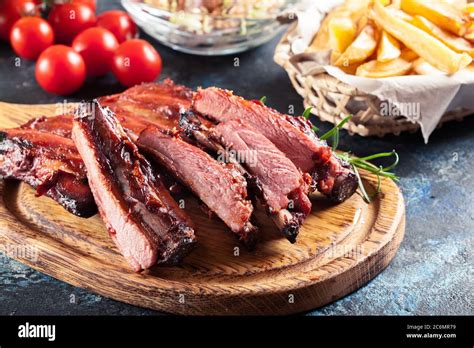 Spicy Barbecued Pork Ribs Served With Bbq Sauce On Chopping Board Stock