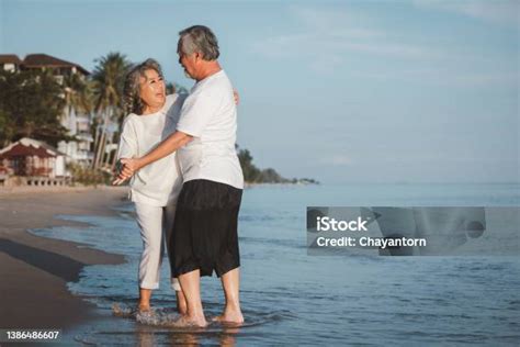 여름 해변 일몰에 서있는 동안 춤을 낭만적 인 아시아 수석 커플 휴가 와 여름 개념에 은퇴 후 여행 레저 및 활동 휴가 와 휴식 시간 2명에 대한 스톡 사진 및 기타 이미지