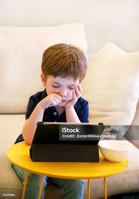 가정에서 침대에 태블릿 Pc를 사용 하는 아이 소파에 귀여운 소년은 만화를 보고 게임을 재생 하 고 노트북에서 학습 교육 재미 레저 행복 현대 컴퓨터 기술 및 통신 교육에