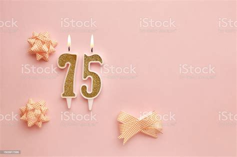 축제 장식이 있는 파스텔 핑크 배경에 숫자 75가 있는 양초 생일 축하 촛불 생일 기념일 중요한 날짜 휴일을 축하하는 개념입니다