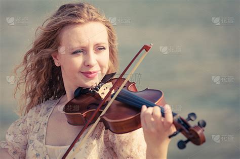 在海滩附近拉小提琴的女人