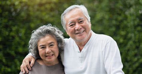 아시아인 노부부의 초상화는 미소를 지으며 공원에서 카메라를 바라보고 있다 야외에서 긍정적 인 느낌을 가진 행복한 노인 퇴직