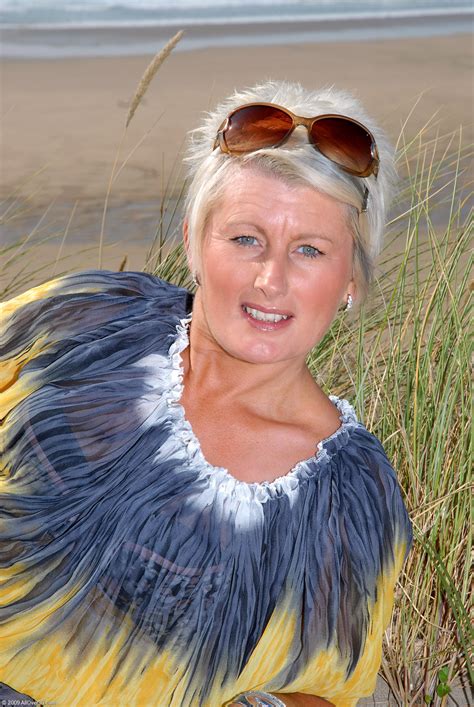 Зрелая блондинка с короткой стрижкой Салли Ти обнажает свои маленькие соски и проколотую киску