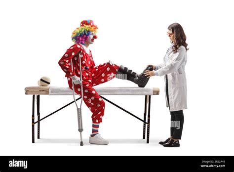 Injured Clown With A Walking Brace Sitting On A Therapy Bed And Doctor