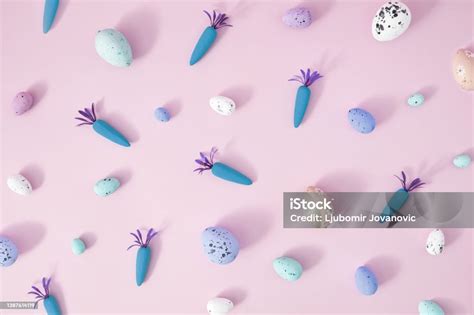 파스텔 보라색 배경에 창조적 인 봄 부활절 개념 분홍색 노트 또는 초대를 위해 계란과 당근을 칠했습니다 플랫 레이 0명에 대한
