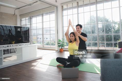 아시아 젊은 아름 다운 여자 연습 요가 와 팔을 스트레칭 하 여 남자 트레이너 에 거실 건강 한 실내 스포츠 활동 20 24세에