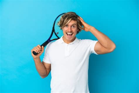 Premium Photo Blonde Tennis Player Man Isolated On Blue With Surprise