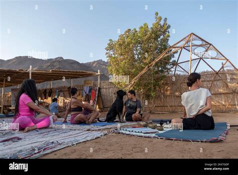 women practice yoga in ras el satan or ras shaitan beach resort area