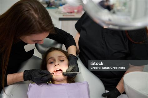 여성 치과 의사 의사는 어린 소녀에게 치과 검진이나 치아 치료를 수행하여 치과 진료소에서 충치를 치료합니다 3 명에 대한 스톡 사진 및 기타 이미지 Istock