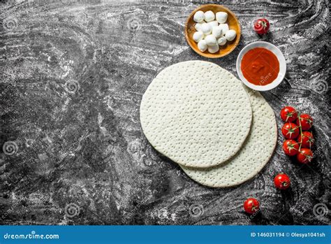 Raw Pizza Rolled Out Dough With Tomato Paste Tomatoes And Cheese