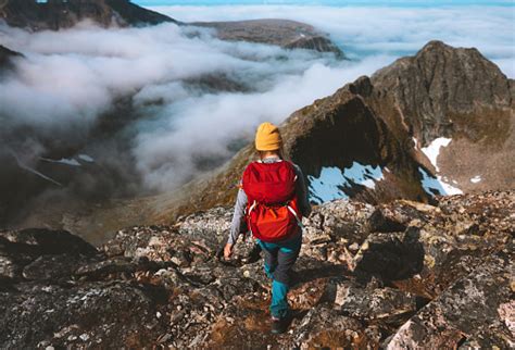 노르웨이에서 레드 백팩 어드벤처 여행 라이프 스타일 등반 솔로 활성 여름 휴가 야외 익스트림 투어와 함께 산에서 혼자 하이킹하는 여성 크로스 컨트리 러닝에 대한 스톡 사진