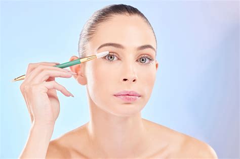 메이크업 초상화 그리고 화장품과 스킨케어를 위한 파란색 배경에 눈에 붓을 든 여자 마스카라 도구 속눈썹과 자연의 아름다움
