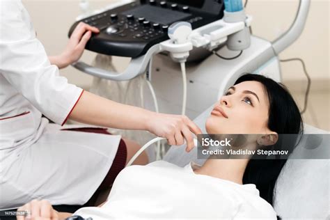 현대 진단 클리닉의 의사는 초음파 기계에서 젊은 매력적인 여성 환자의 갑상선을 검사합니다 갑상선암 예방 갑상샘에 대한 스톡 사진