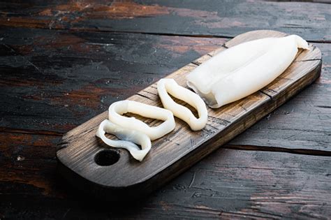원시 오징어 어두운 소박한 나무 배경 위에 도마에 반지 슬라이스 칼라마리에 대한 스톡 사진 및 기타 이미지 칼라마리 날것