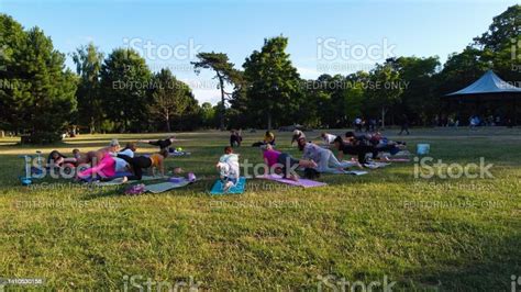 더운 여름의 일몰에 공공 공원에서 함께 요가를 운동하는 여성 그룹 Wardown Park Luton England Uk의 공중