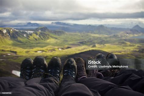 아이슬란드에서 Landmannalaugar 계곡이 내려다 보이는 산 위에 앉아 친구 등산화에 대한 스톡 사진 및 기타 이미지