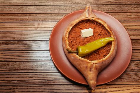 맛있는 전통 아자리안 카차푸리의 최고 전망 나무 쟁반에 고기와 페퍼라요르크를 곁들인 오픈 구운 파이 전통 그루지야어 음식 0명에