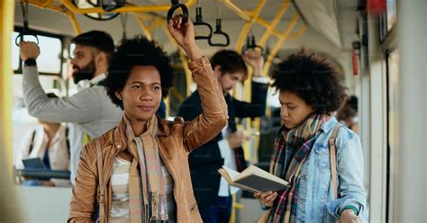 버스로 통근하는 동안 테이크아웃 커피를 들고 있는 중년 흑인 여성 사진 Unsplash의 대중교통 이미지