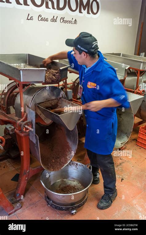A Worker Regrinds The The Once Ground Roasted Cacao Beans Cinnamon Sticks And Sugar In A