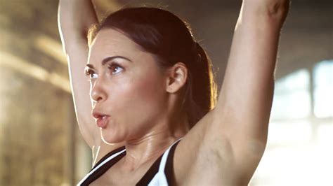 美丽的女运动员wipes用手从前额流汗。经过密集的交叉健身锻炼，她累了。模板素材 稿定设计