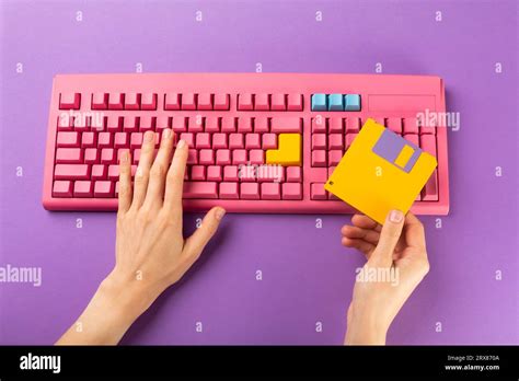 Hand Holding Floppy Disk On Color Keyboard Background Technology