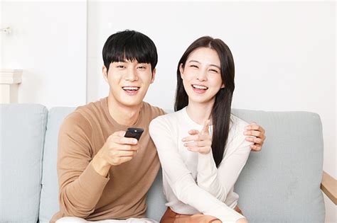 유토이미지 상세페이지 베이직샵 21874261 소파에 앉아 리모콘들고 티비보고있는 커플
