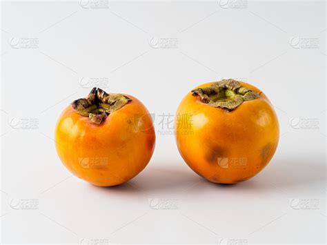 白色背景上孤立的两个柿子。
