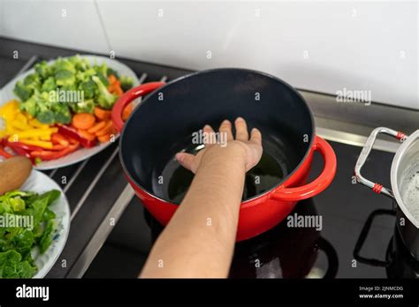 Hand Controlling The Temperature Of The Pot Stock Photo Alamy