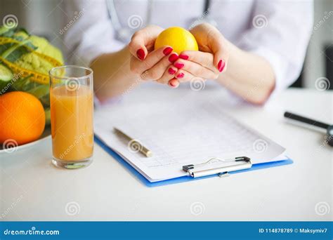 Foto Conceptual De Un Nutricionista De Sexo Femenino Con Las Frutas En El DES Imagen De Archivo