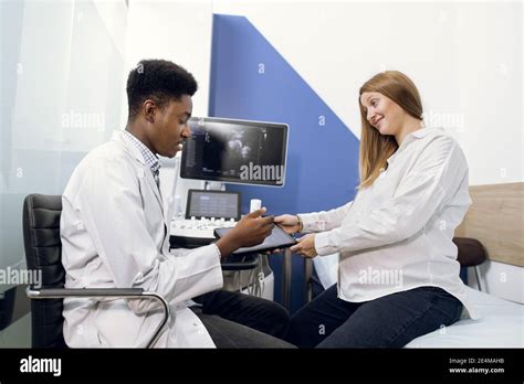Doctor And Patient In Ultrasound Room African Male Doctor Talking To