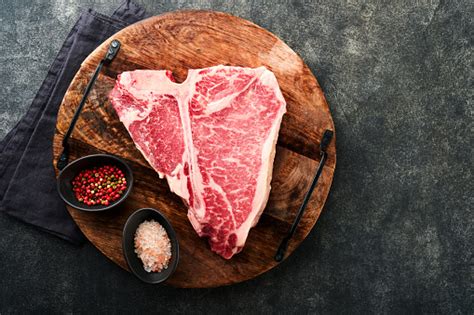 두꺼운 생 티본 스테이크 드라이 에이징 생 티본 또는 포터하우스 쇠고기 고기 어두운 배경에 허브와 소금으로 멧돼지를 자르는 스테이크 평면도 및 복사 공간 0명에 대한 스톡