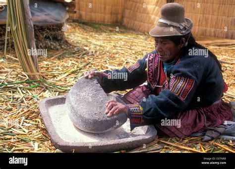 Elderly Woman Of The Aymara Indigenous People Grinding Corn Into Flou