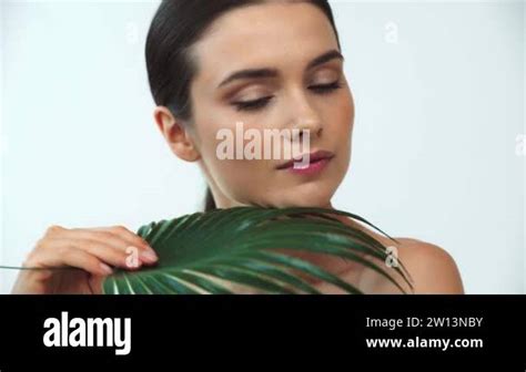 Beautiful Naked Woman Holding Leaf Of Tropical Plant On Grey Background