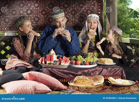 Узбекская семья имеет завтрак с плоскими тортами Стоковое Фото изображение насчитывающей