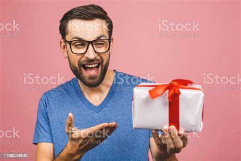 멋진 선물 분홍색 배경 위에 고립 된 생일 선물 상자를 들고 아름다운 미소와 매력적인 남자의 사랑스러운 사진 12월에 대한 스톡