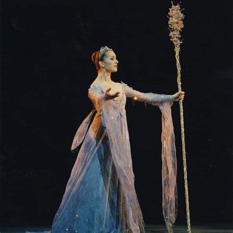 A Woman In A Blue Dress Holding A Pole And Wearing A Tiara With