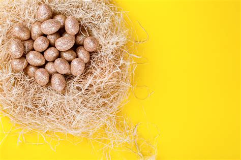 노란 종이에 둥지에 황금 페인트 부활절 달걀과 부활절 배경 행복 한 축제 개념입니다 평면도 평평한 누워 텍스트에 대 한 공간