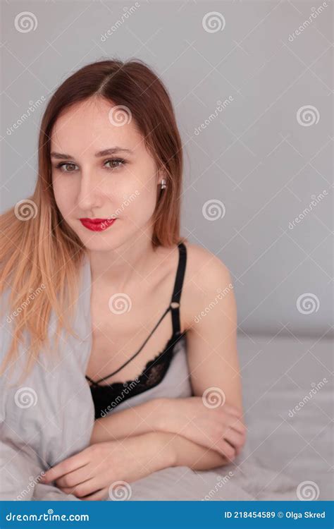 Portrait Of Pretty Redhead Woman In Black Lingerie On Bed With Grey
