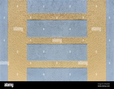 Two Tone Pattern Of Blue Rectangular Areas In Yellow Grainy Plaster
