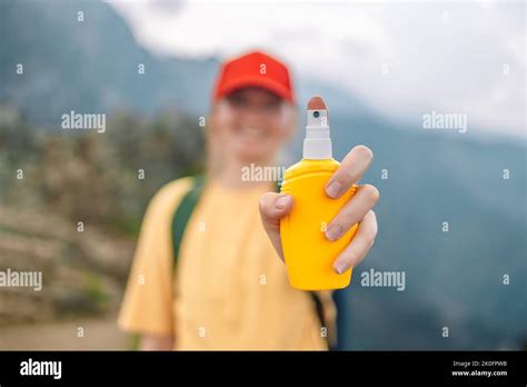 Woman Applying Insect Repellent Against Mosquito And Tick On Her Hand During Hike In Nature Top